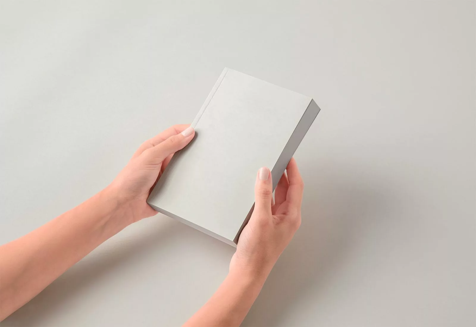 Hands Holding Paperback Book Cover Mockup | The Free Mockup